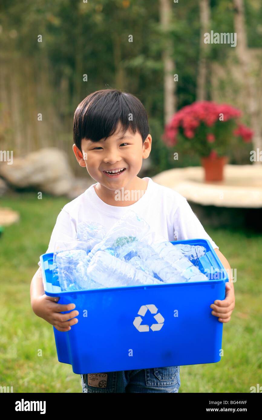 boy holding recycling container with empty plastic bottles inside Stock ...