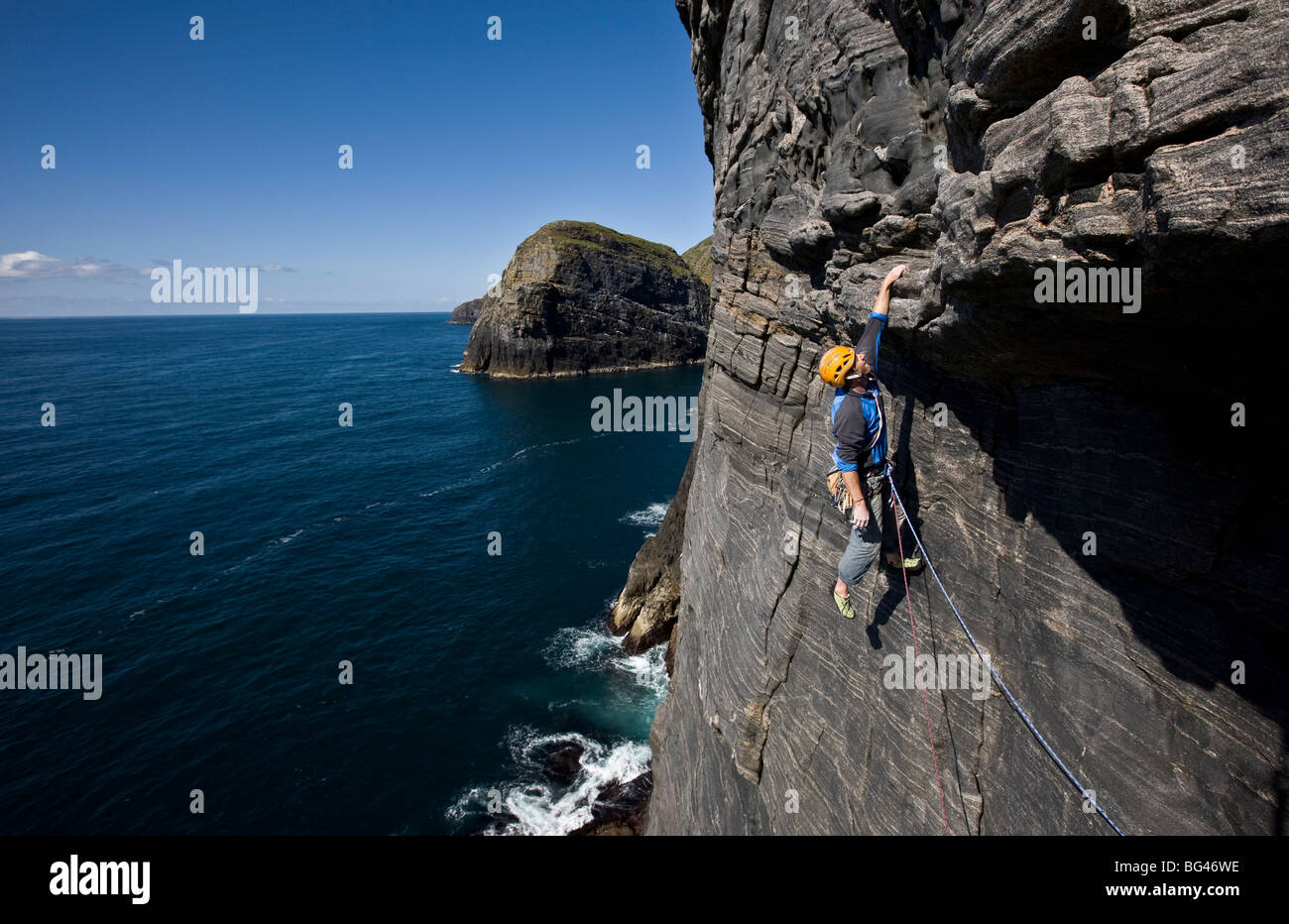 A climber hangs above the sea,west face of Dun Mingulay cliff, Mingulay ...