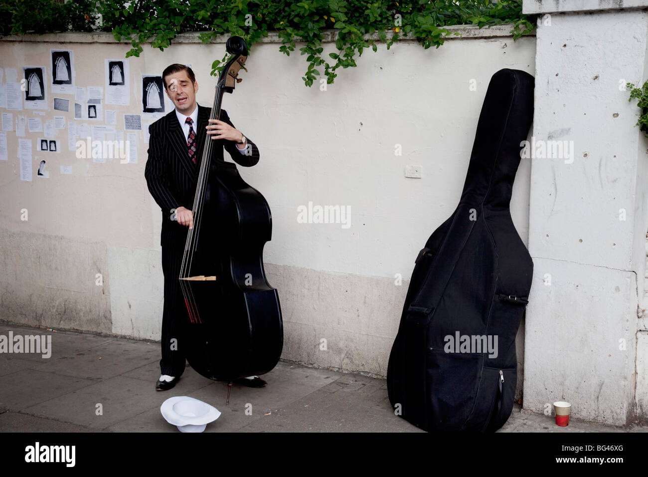 Busker playing a double bass on Portobello Road, London Stock Photo - Alamy