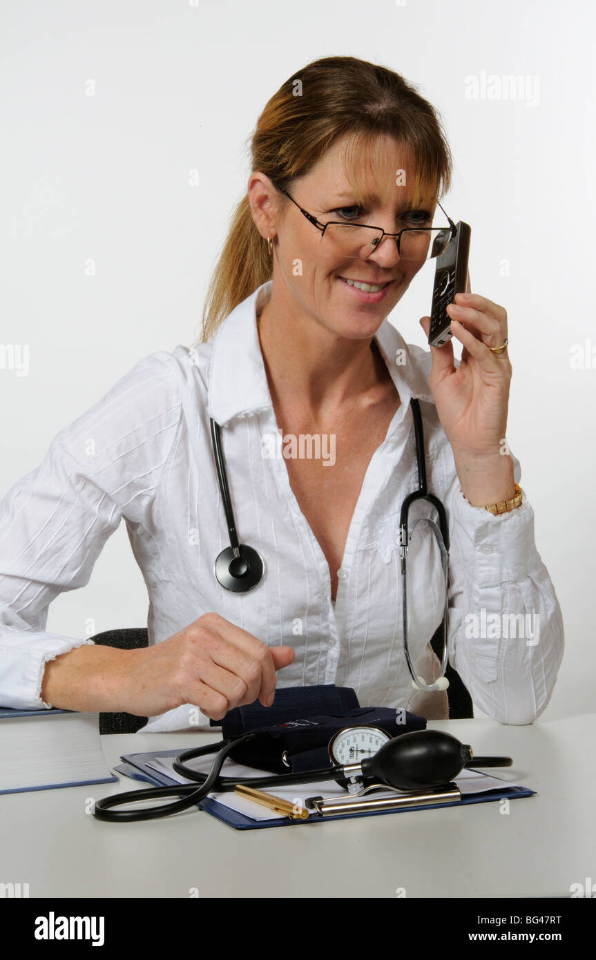 Female doctor taking or making a telephone call from her desk Stock ...