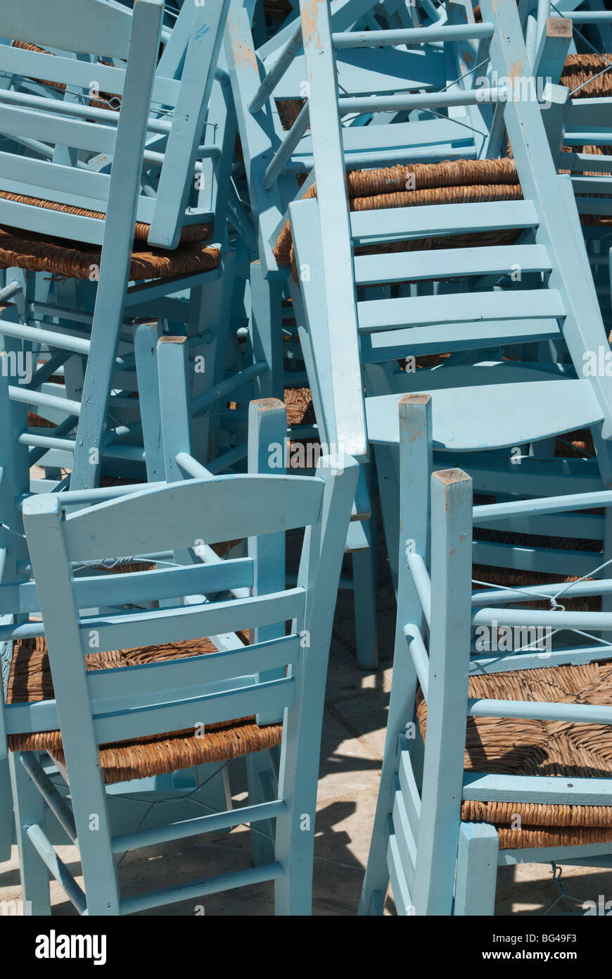 Messy stacked blue cafe chairs at a Greek taverna on Milos Island Stock ...