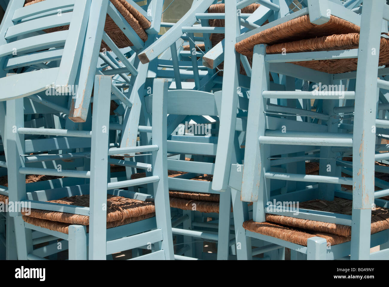Messy stacked blue cafe chairs at a Greek taverna on Milos Island Stock ...