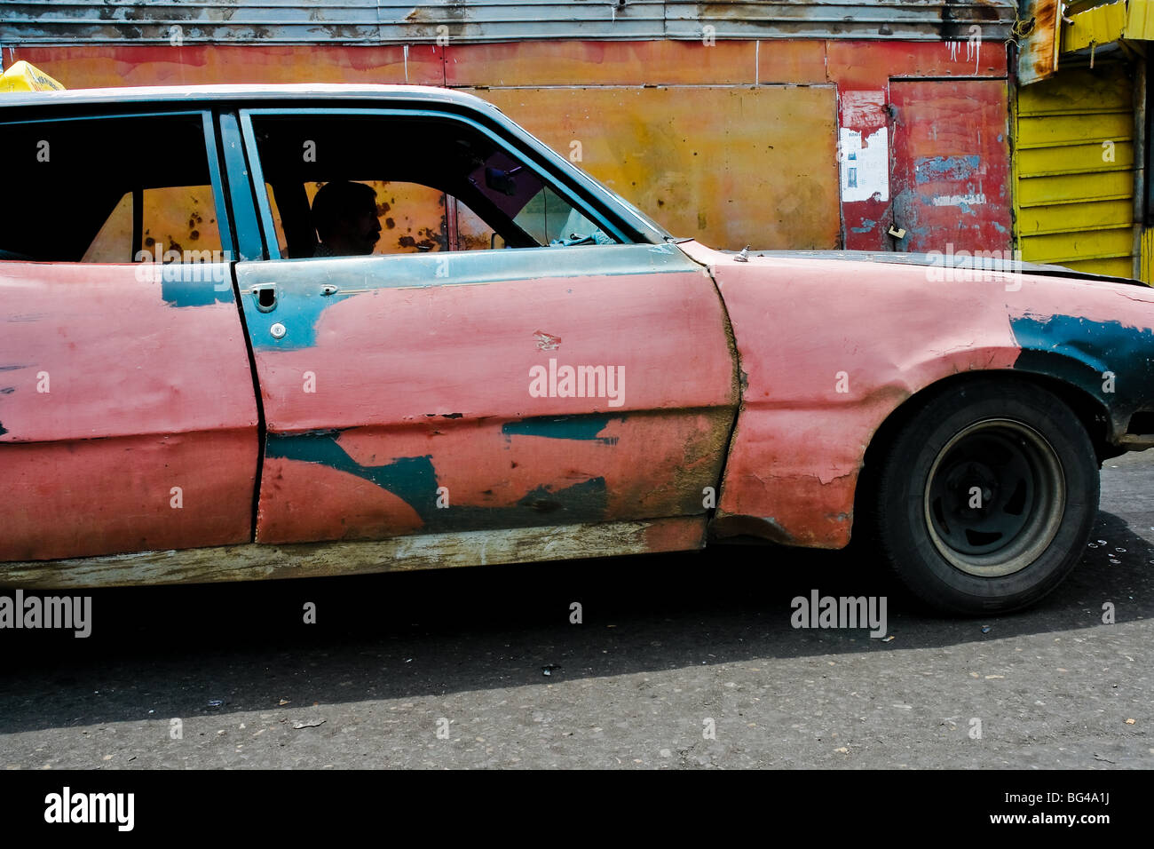 A rusty and damaged American classic car from 1970s, used as a shared ...