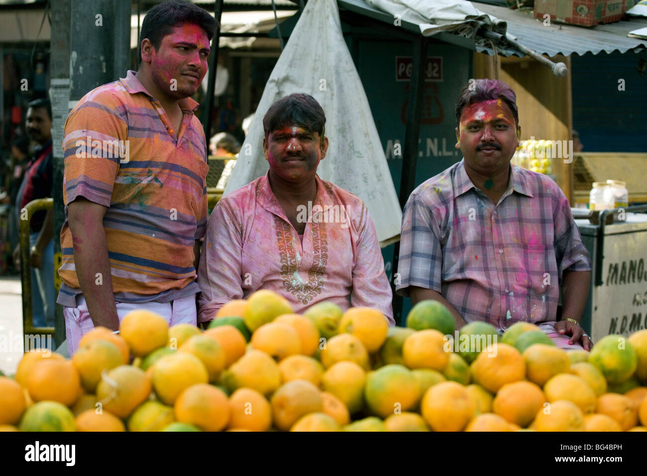 Three Indian men enjoy Holi at a fruit stall in the Paharganj area of ...