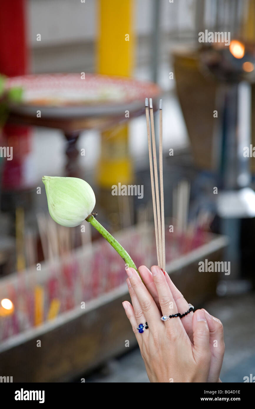 Thai Woman Praying With Lotus Flower And Incense Sticks In Her Hands
