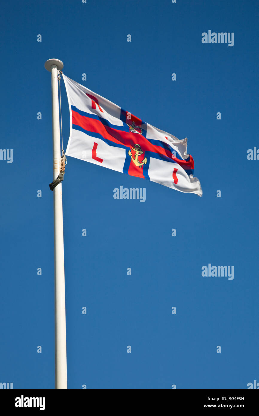 Flag of the Royal National Lifeboat Institution against a blue sky ...
