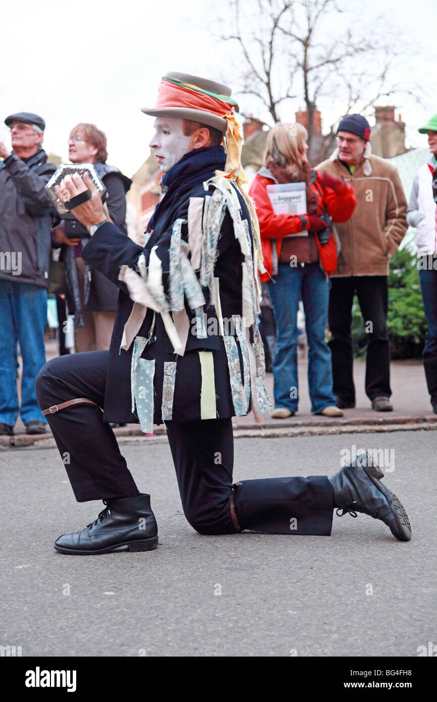 A traditionally dressed mummer playing a concertina during a street ...