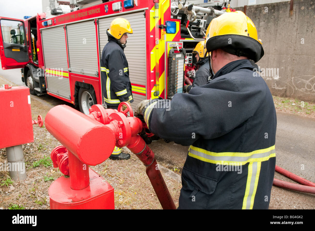Firefighters setting in to hydrant at oil refinery Stock Photo - Alamy
