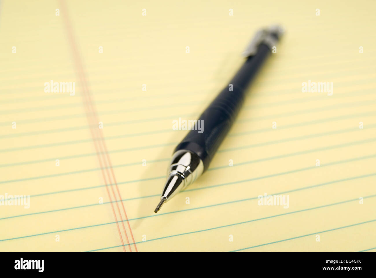 Blue mechanical pencil on a yellow legal pad. Focus on the tip of the ...