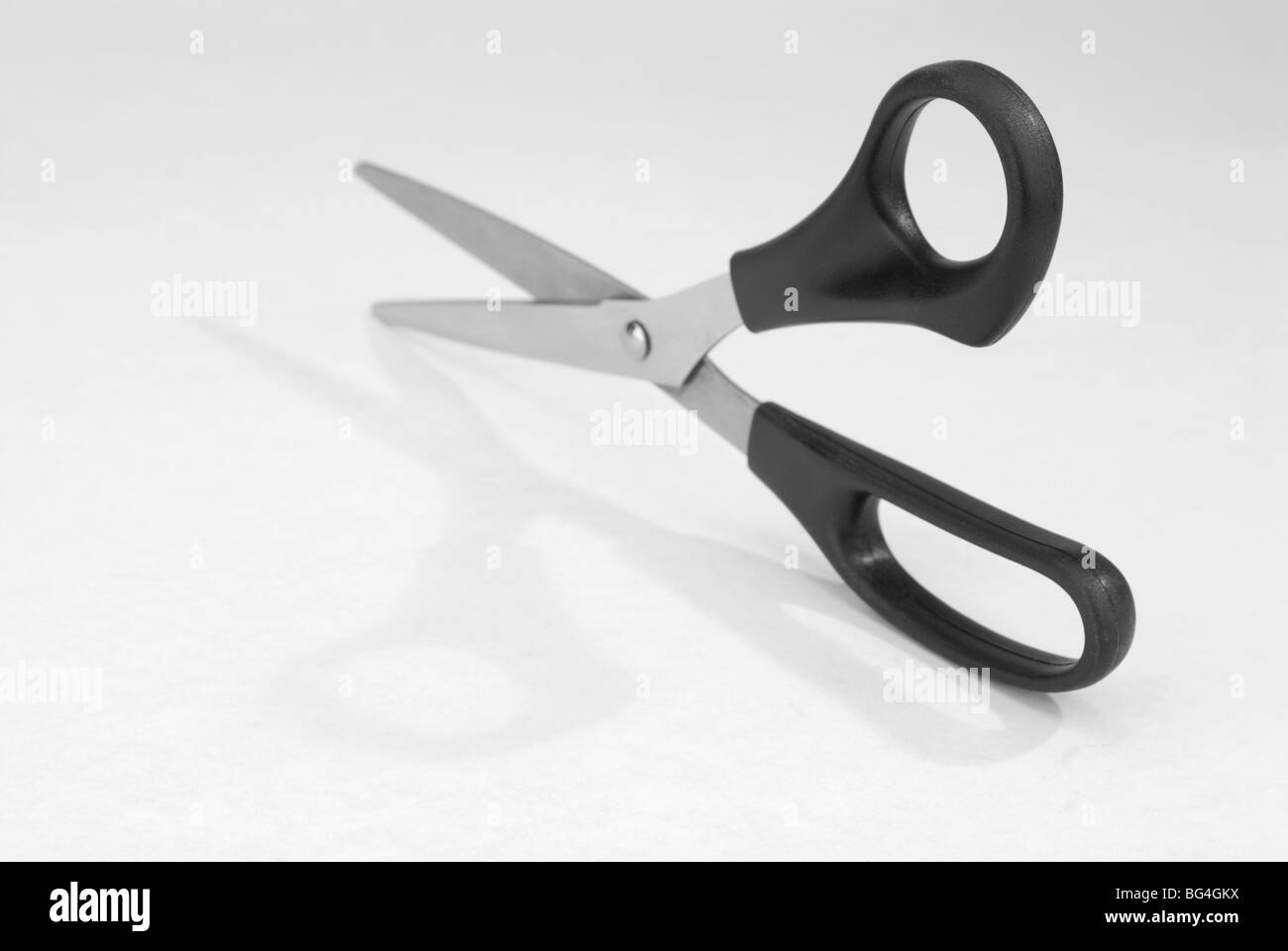 Black handled scissors balancing on a white background Stock Photo - Alamy