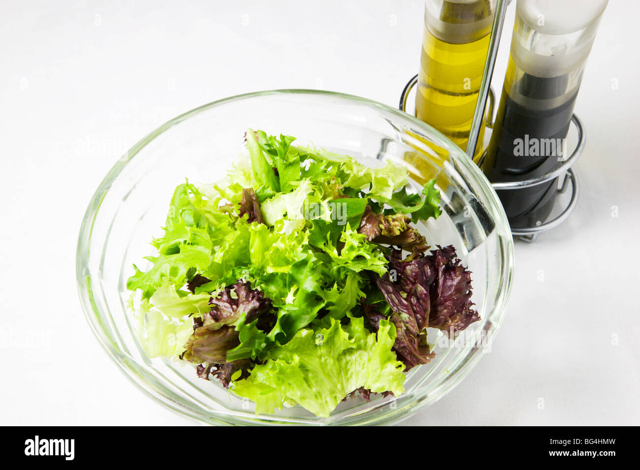 Mixed Frilly Lettuce Leaves in a Glass Bowl with Oil and Vinegar Stock ...
