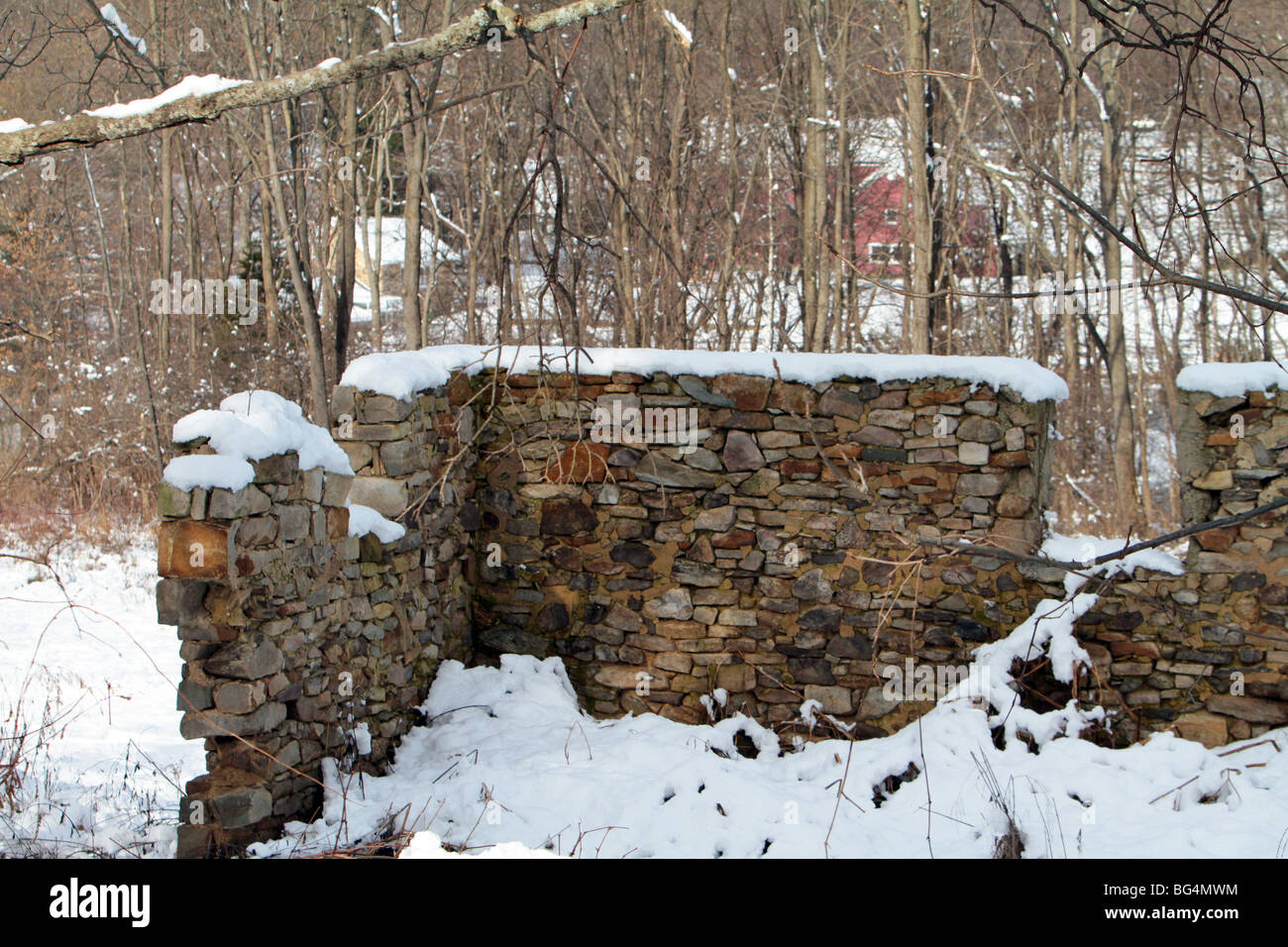Ruins of an old stone barn covered in snow. Just the stone foundation ...