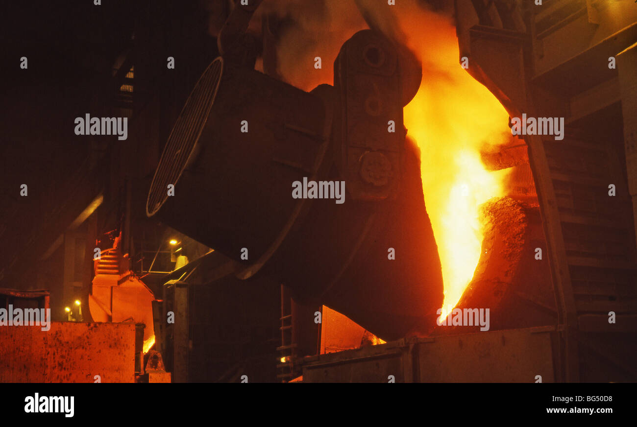 Molten iron being poured from a transfer ladle into a refining vessel ...