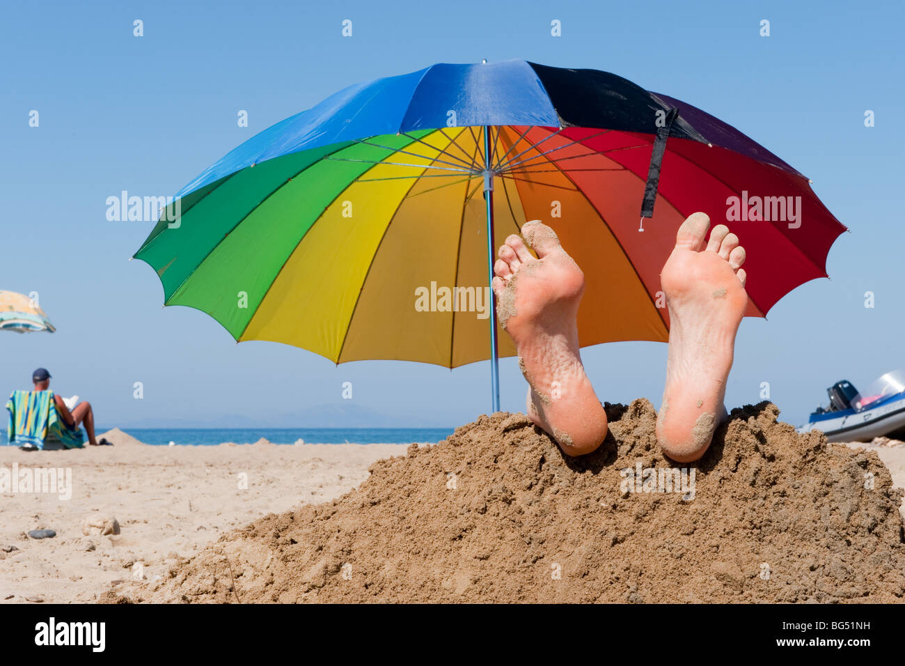 beach vacation in the summer with bare feet and parasol in the sand ...