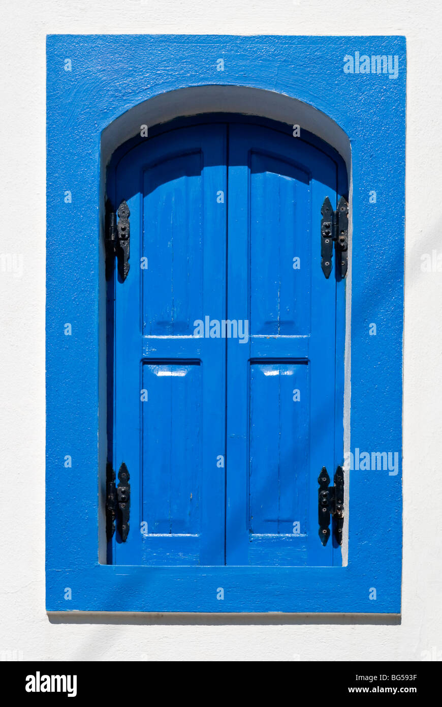 Traditional blue painted shuttered window in a Greek house with white ...