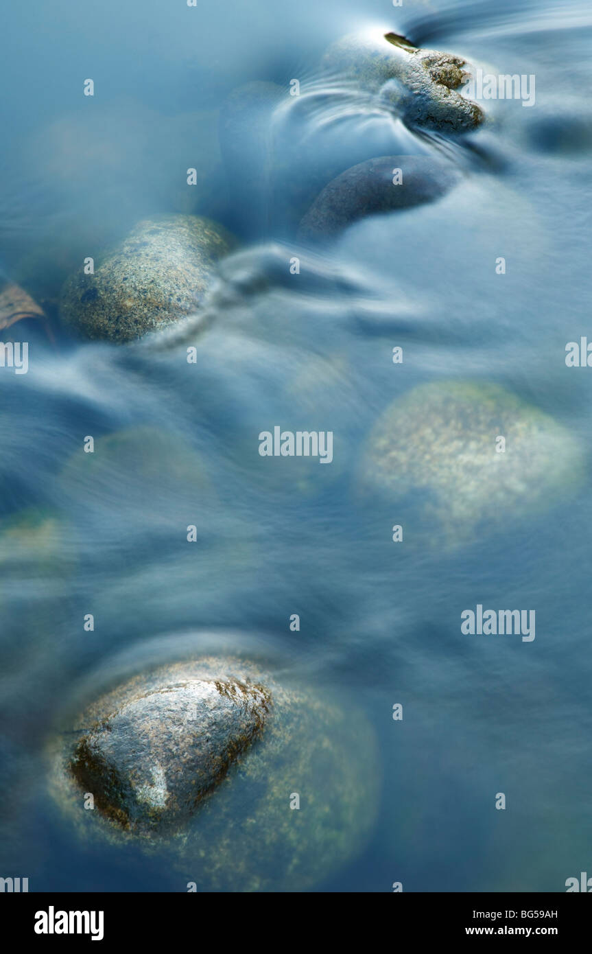 large smooth rocks in the flow of a river Stock Photo - Alamy