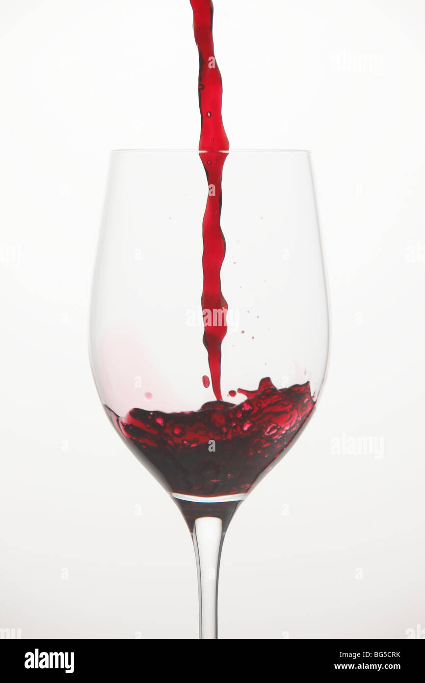 Red wine being poured in to a glass Stock Photo - Alamy