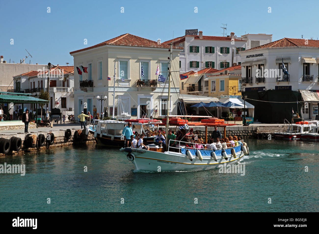 Tour fishing boat leaving harbour at Spetsai, Greece Stock Photo - Alamy
