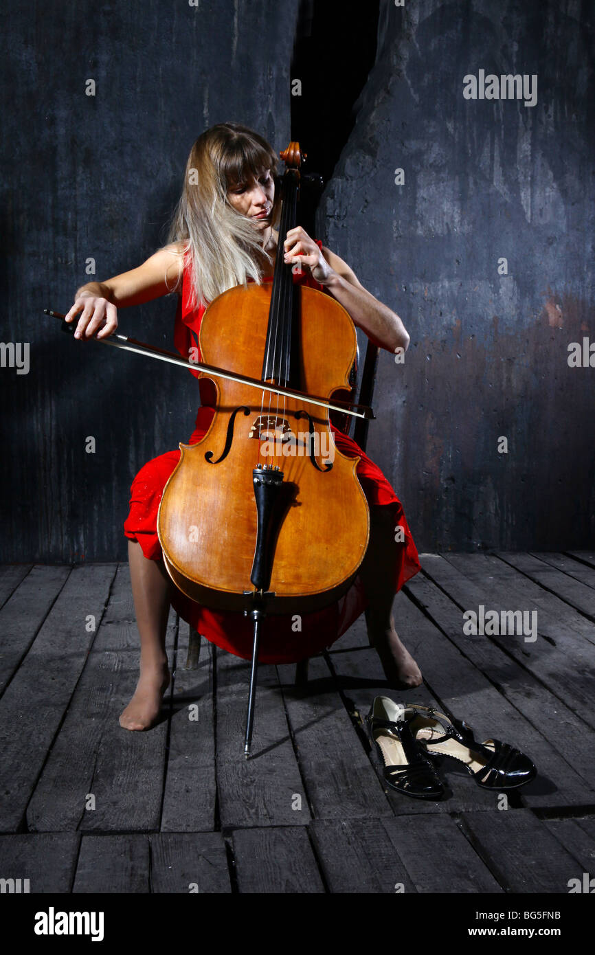 Beautiful cello musician on grey wall background Stock Photo - Alamy