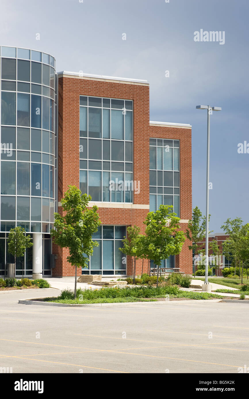 A modern office building in blue glass and red brick, with an empty ...