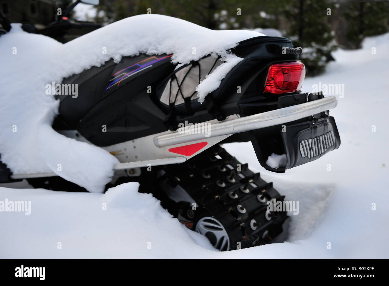 Idle snowmobile covered in snow Stock Photo - Alamy