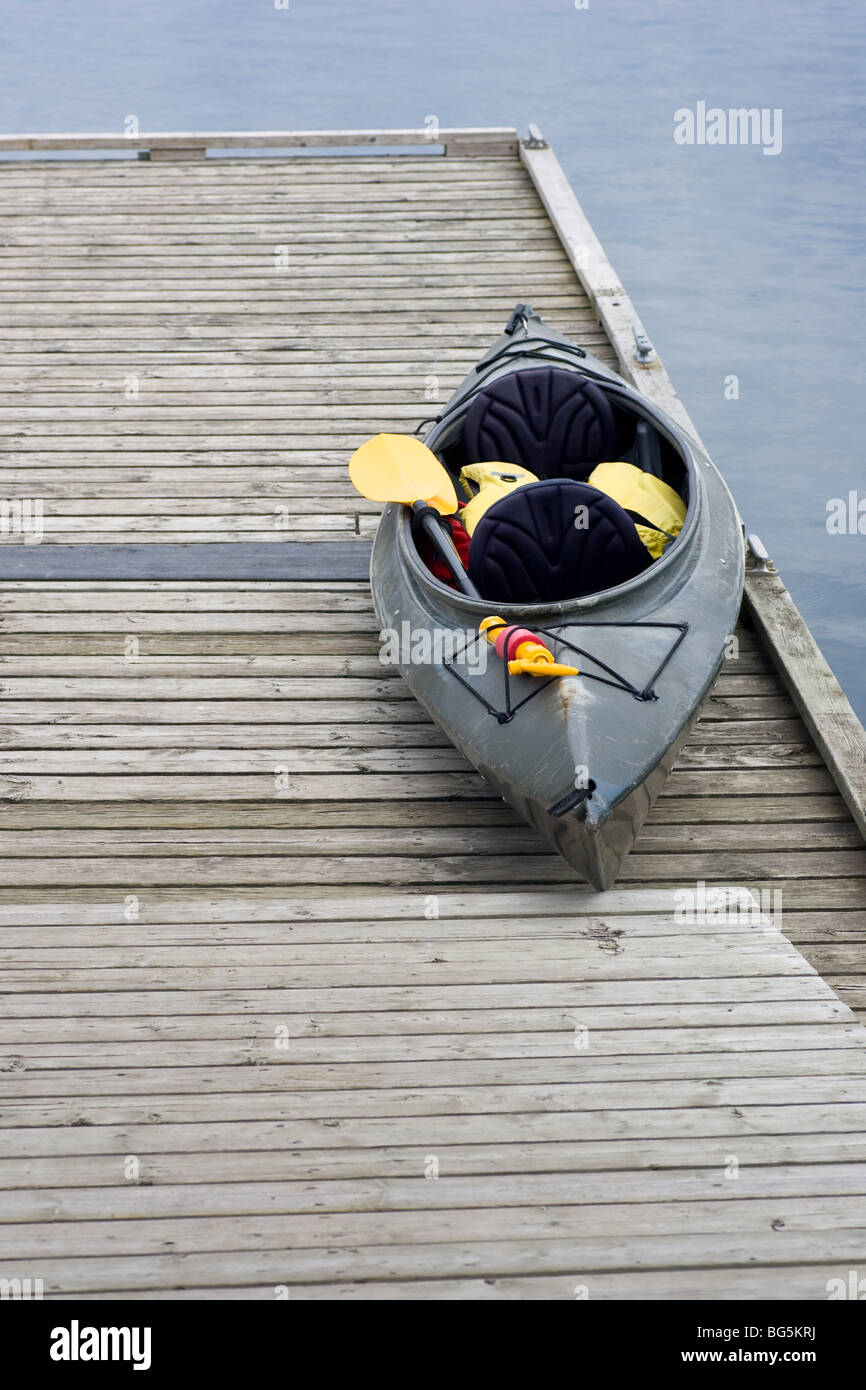 An empty kayak on a wooden dock, at water's edge Stock Photo - Alamy
