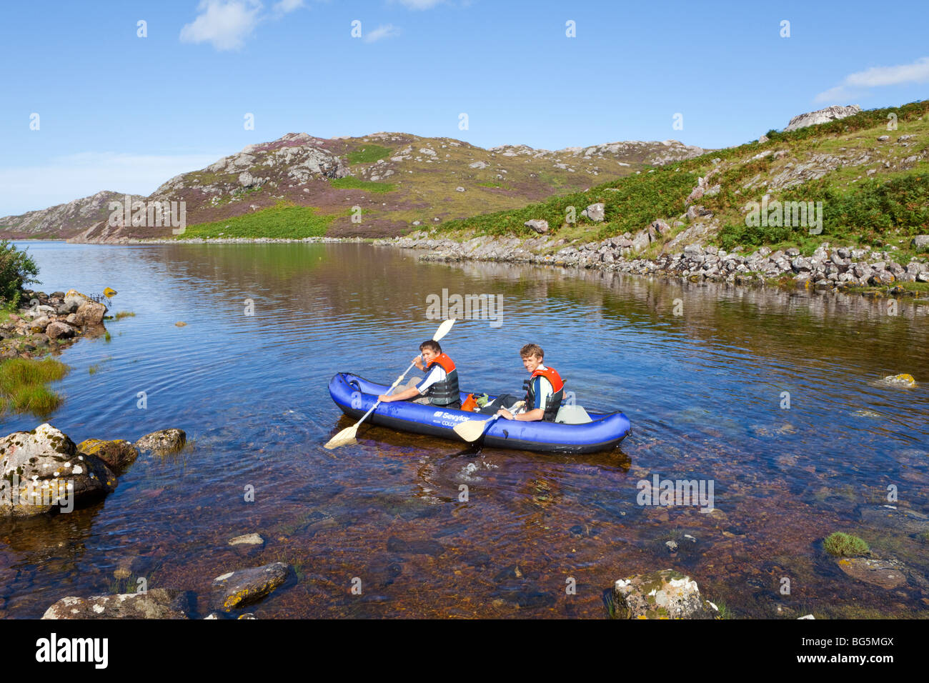 Two brothers setting out in a double inflatable canoe on Loch A Chadh ...