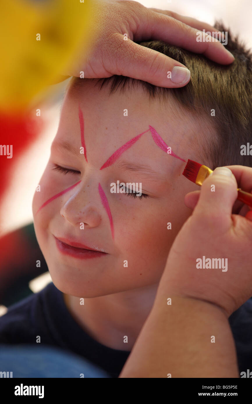 Young boy having his face painted Stock Photo - Alamy