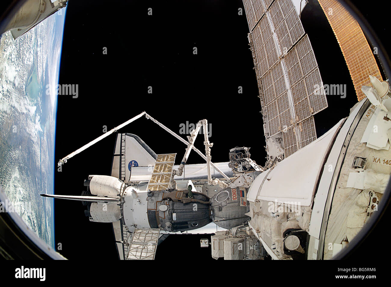 A docked Russian Soyuz spacecraft appears to rest in Space Shuttle ...