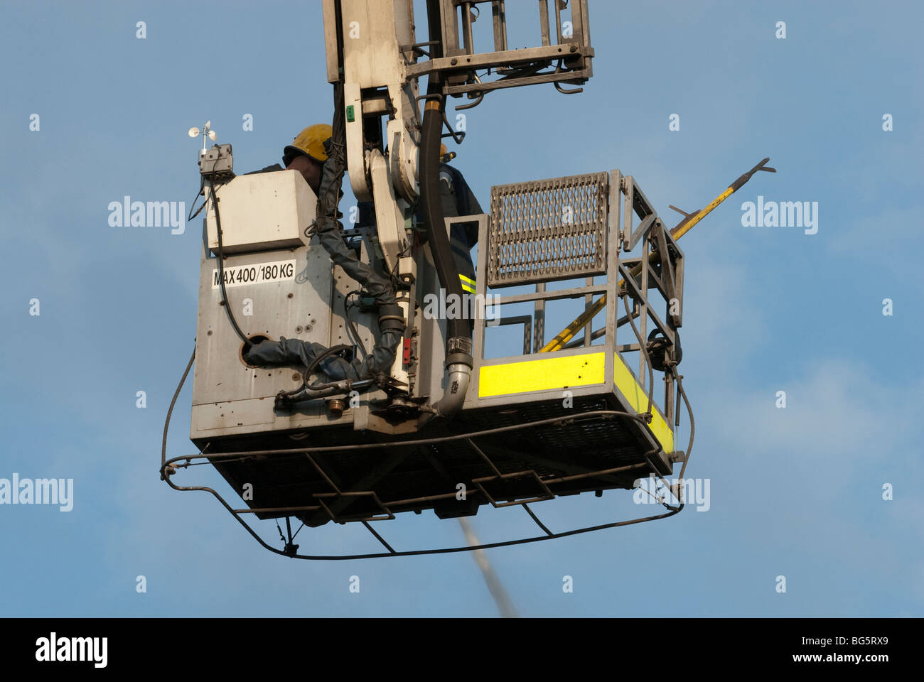 Two firemen in cage of Hydraulic Platform at major fire Stock Photo - Alamy