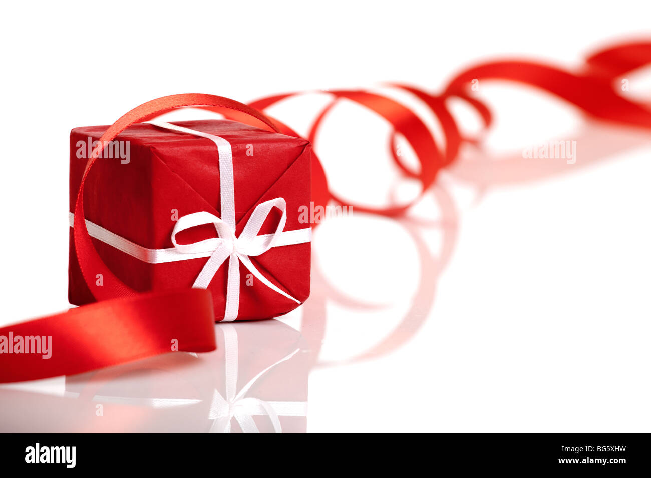 Red gift with a red ribbon over the gift, isolated on white background ...