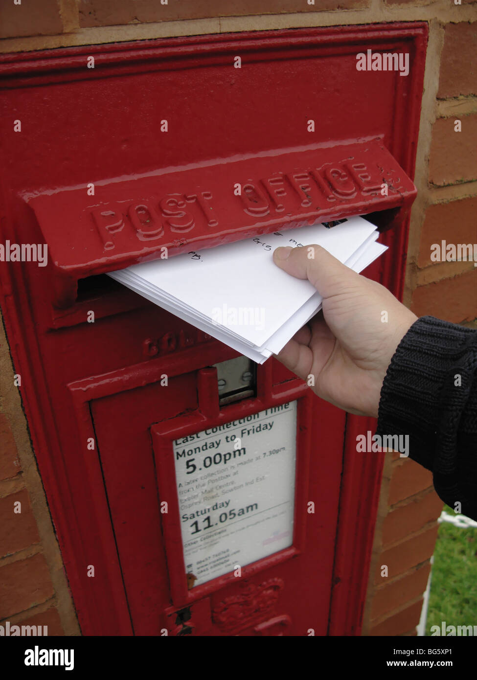 hand posting christmas cards letter in UK post box set in wall Stock ...