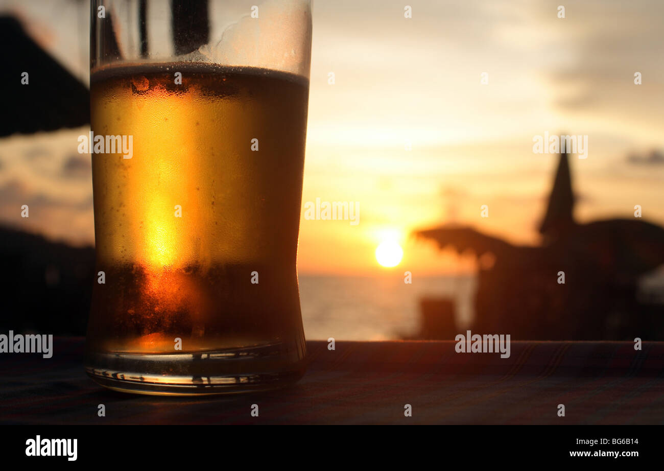Beer in the sunset on the beach Stock Photo - Alamy