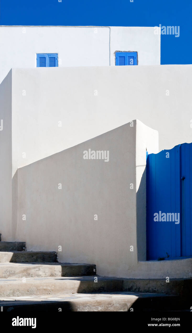 View of typical white painted Greek house with blue shuttered window ...