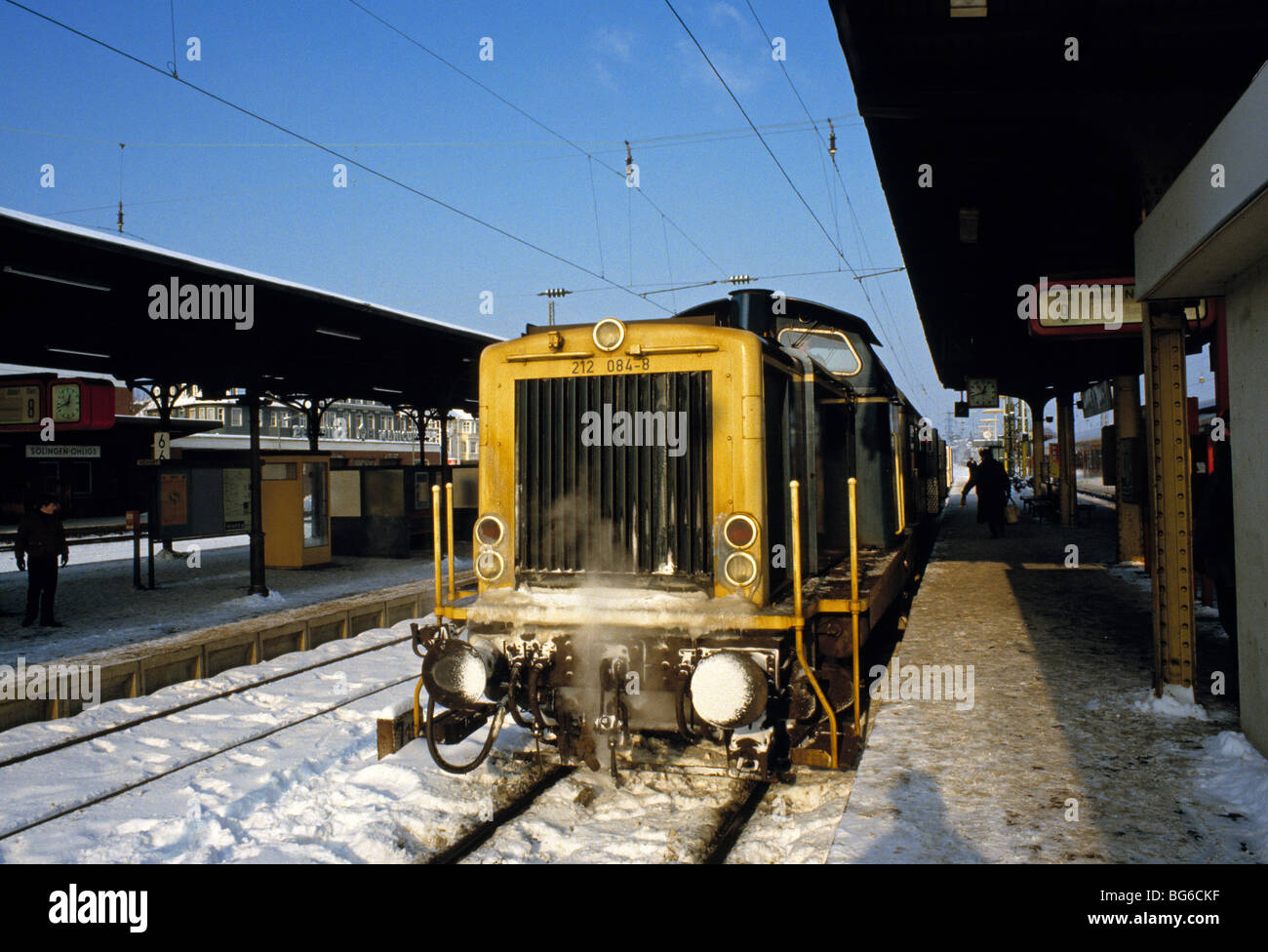 Snow & ice at German railway station with train standing at platform ...