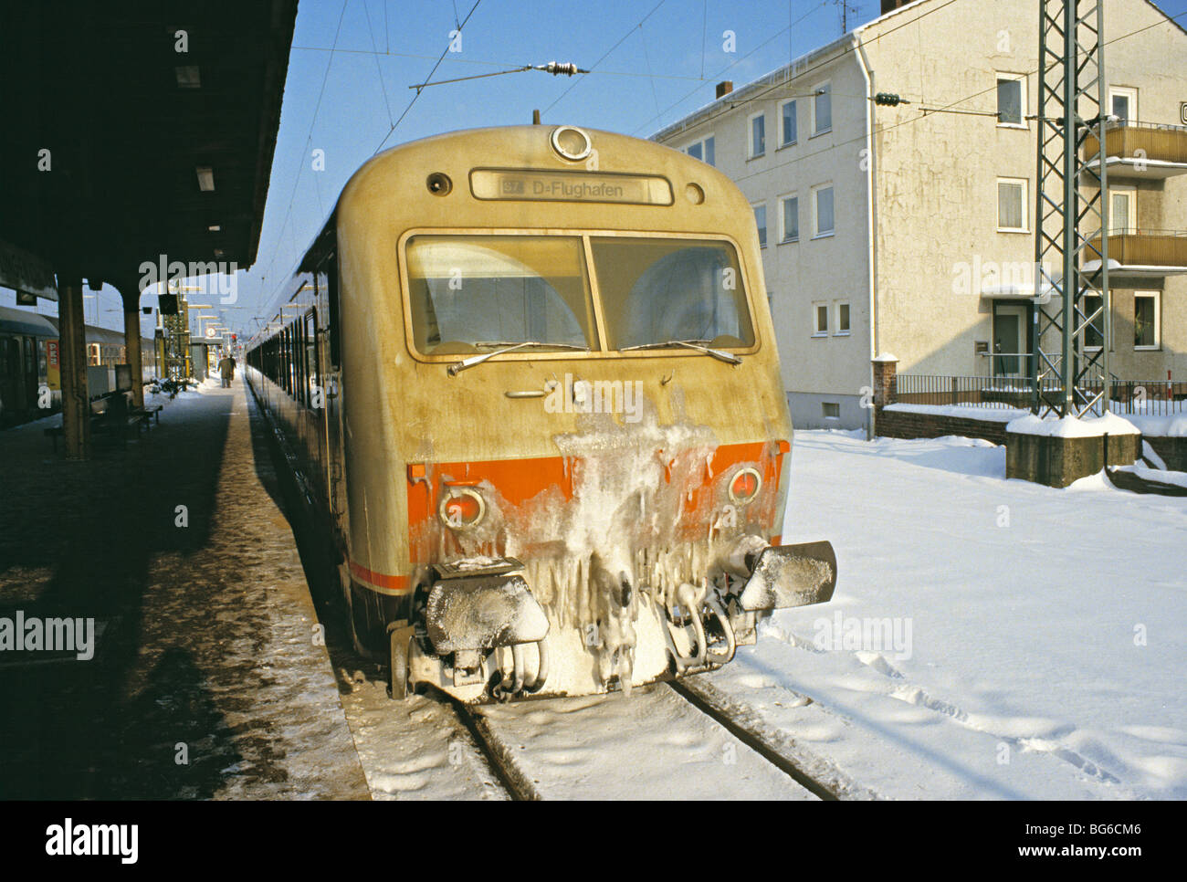 Snow & ice at German railway station with train standing at platform ...