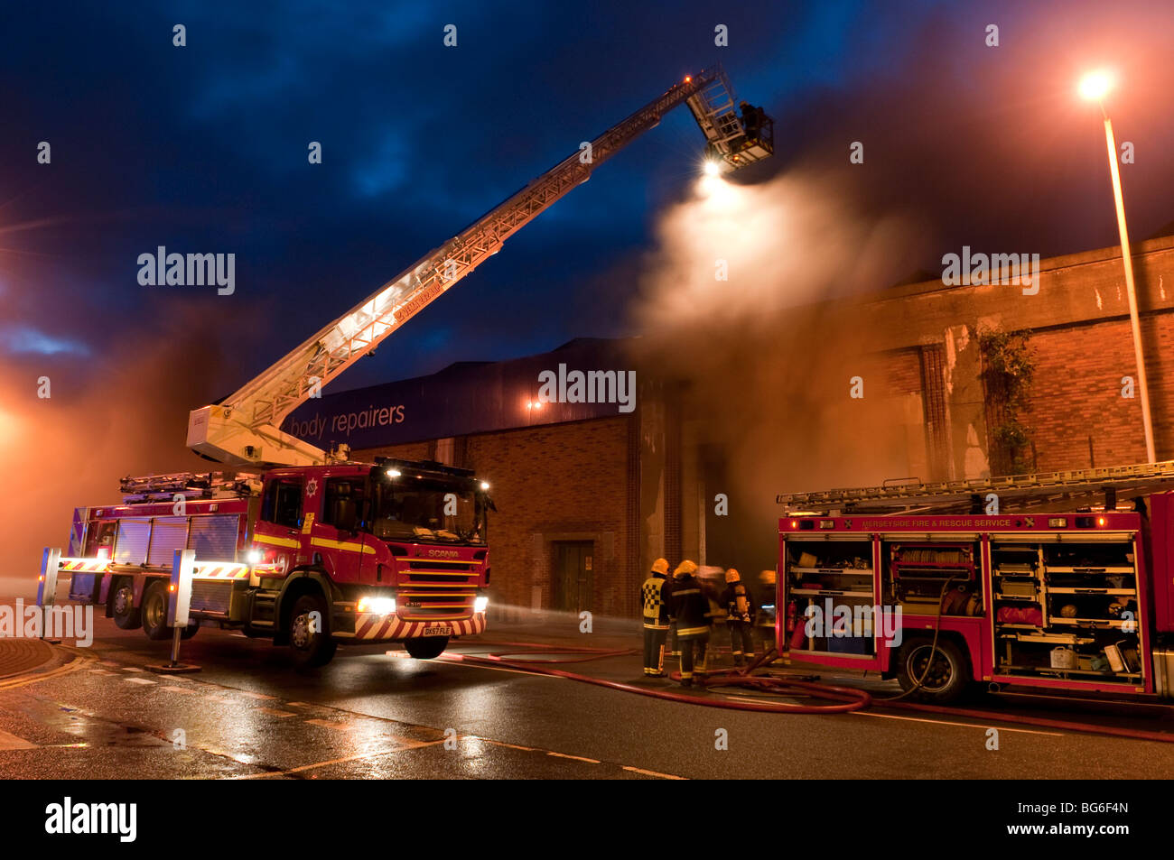 Car repairers on fire at night with Fire Service Hydraulic Platform ...