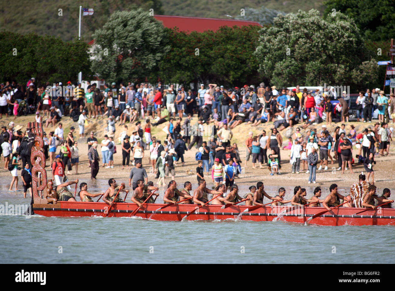 A Waka Taua (war canoe) passes spectators on Te Ti Bay during Waitangi ...