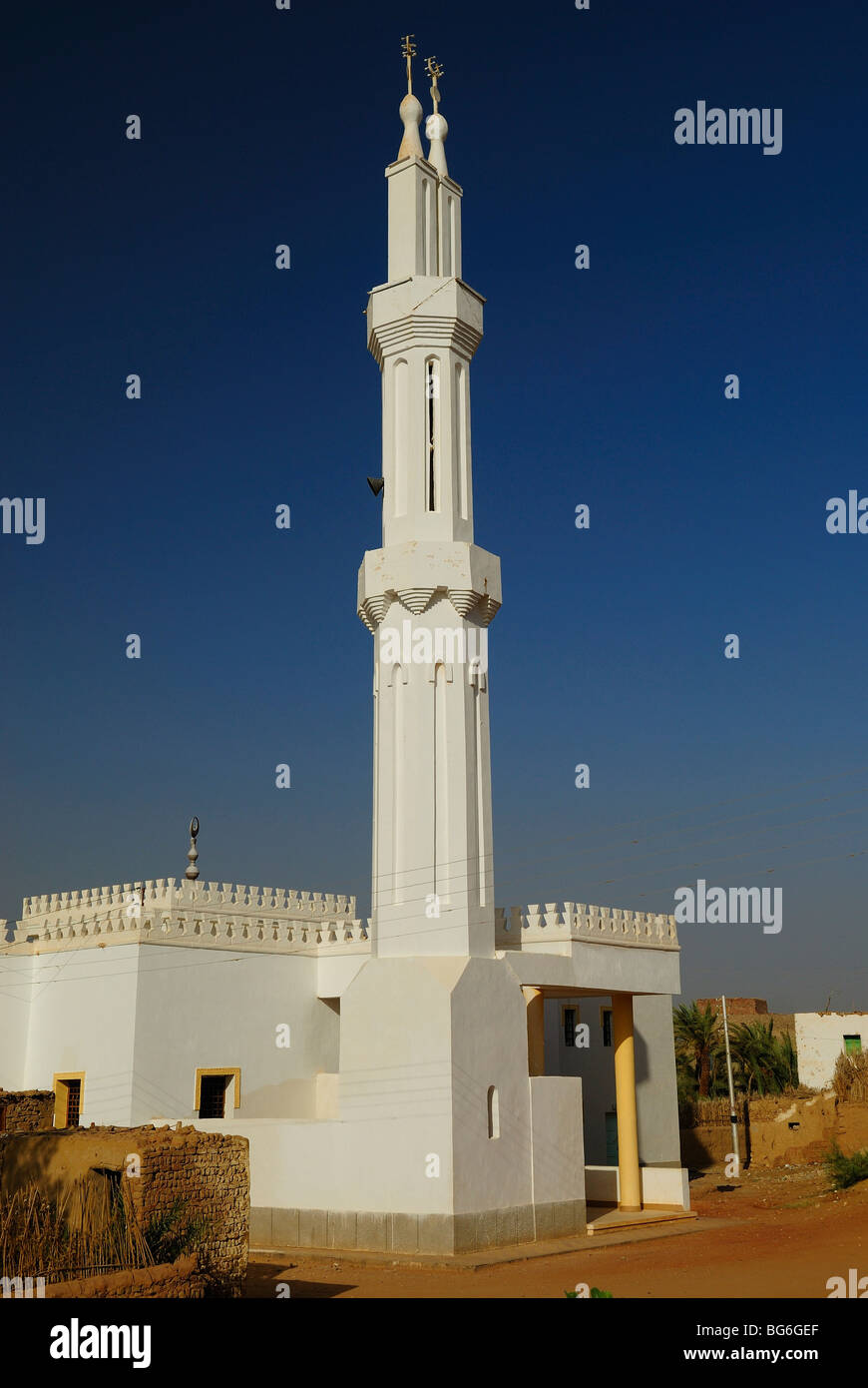 Modern white minaret over the mosque in the the city of Al Qasr in ...