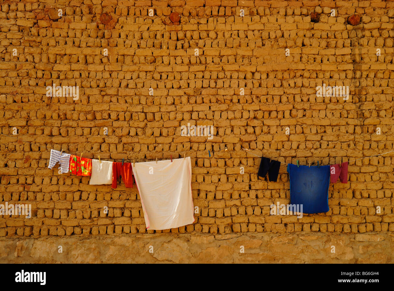 Laundry hanging on a wire to dry in the sun in the the city of Al Qasr ...