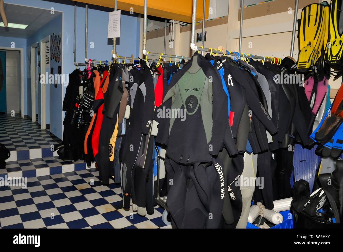 Wet diving suits for scuba divers hanging in a diving center in Monaco ...