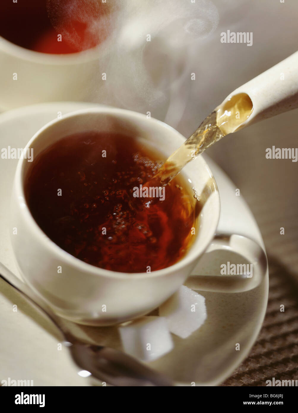 Hot tea pouring into a cup Stock Photo - Alamy