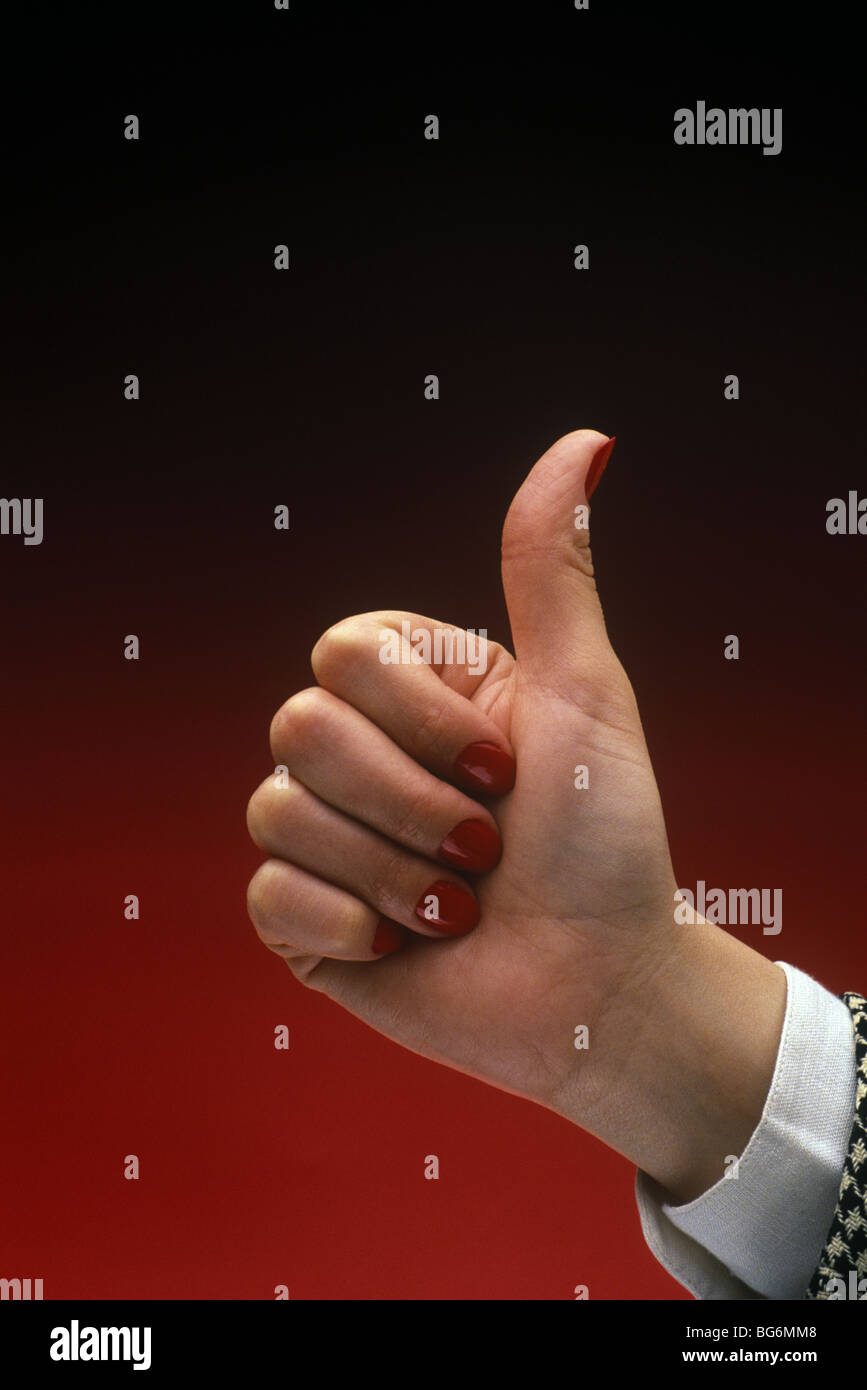 WOMANS THUMBS UP ON PLAIN RED BACKGROUND Stock Photo - Alamy