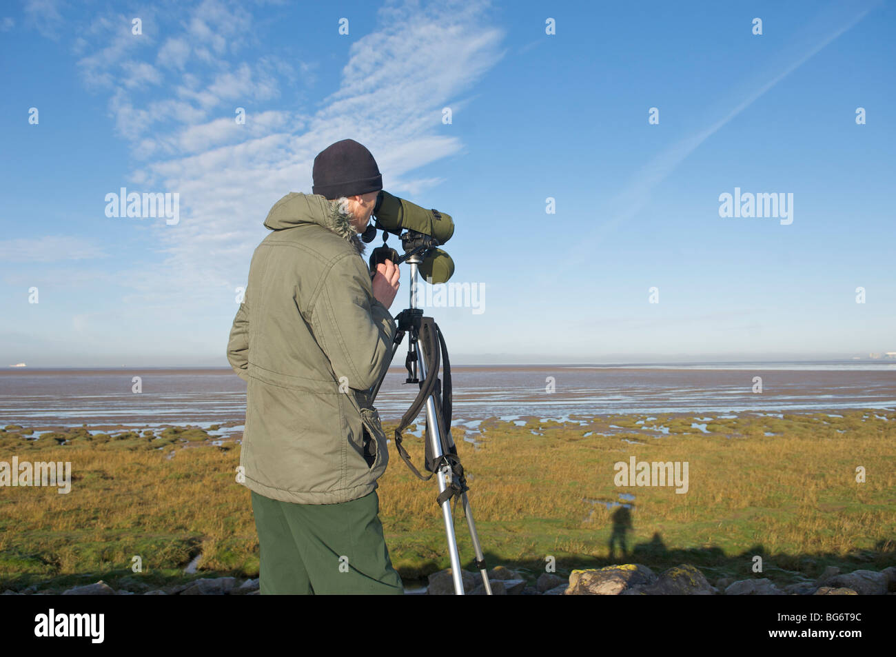 Bird watcher with scope on river estuary Stock Photo - Alamy