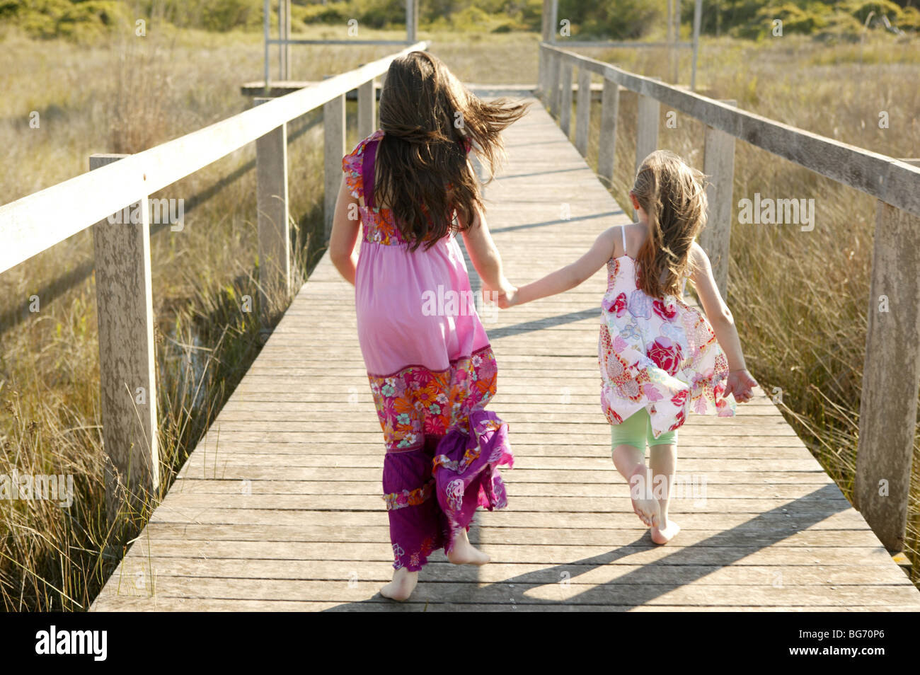 Teen two girls running outdoor at the park, hippy pink dress Stock ...
