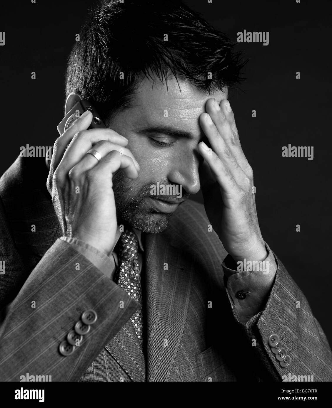 businessman stress with headache and mobile phone over black Stock ...
