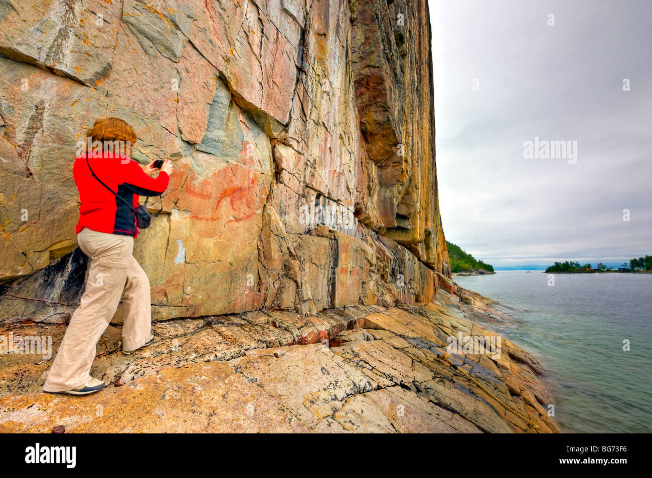 Tourist viewing the ancient pictographs on Agawa Rock, Agawa Rock ...
