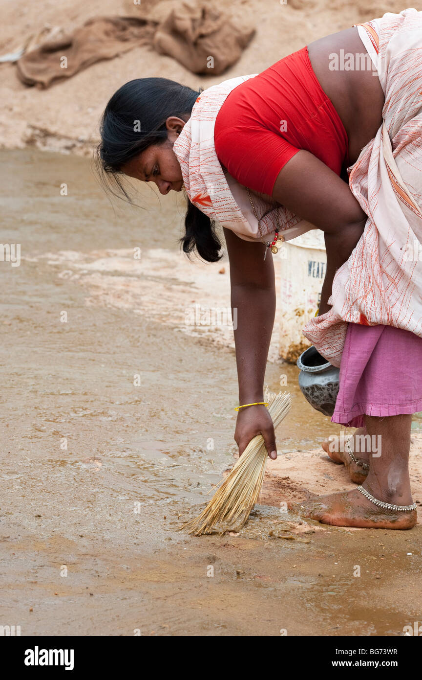 Indian custom of a woman spreading watered down cow dung outside the ...