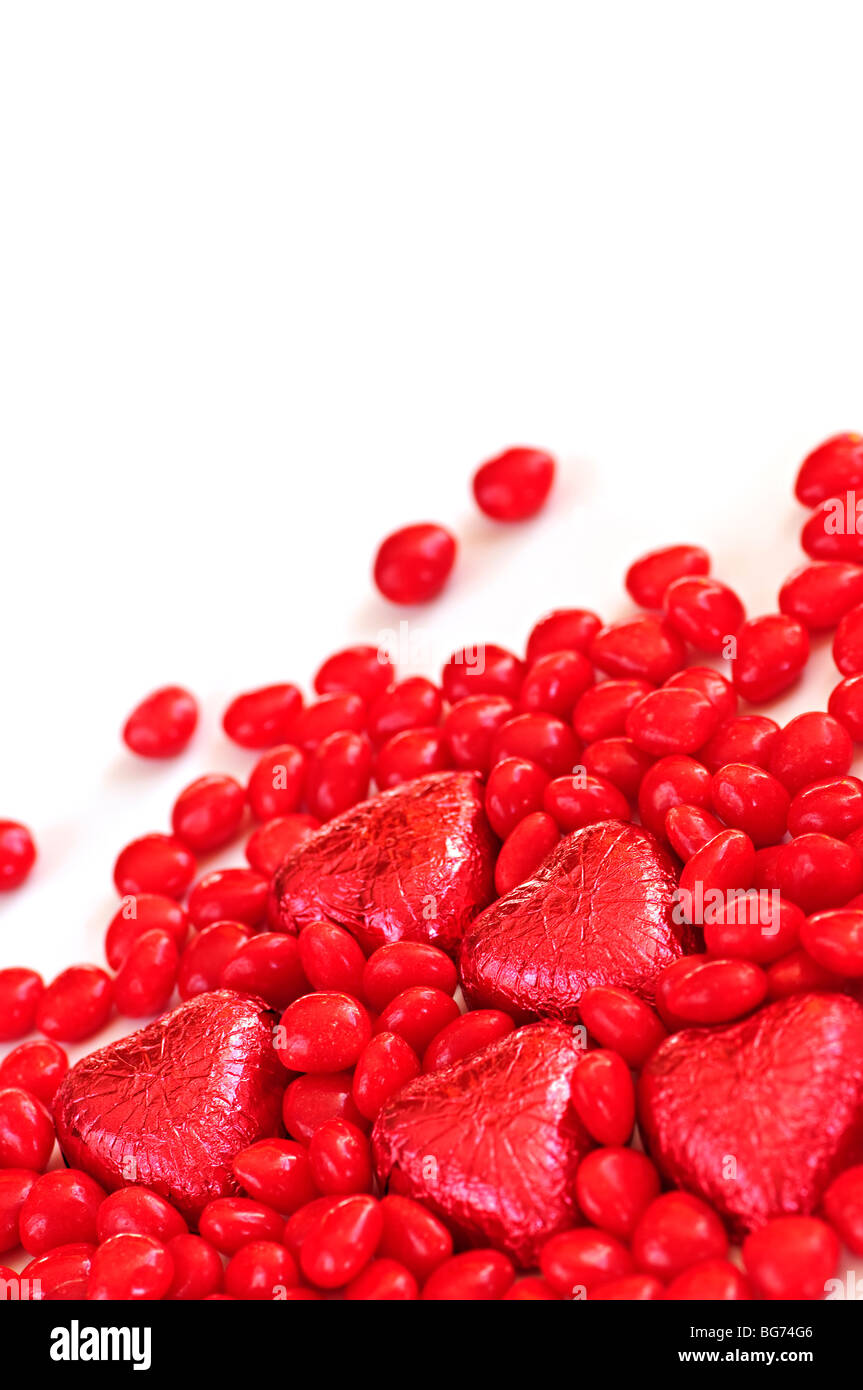 Red Valentine's candies and foil wrapped chocolates on white background ...