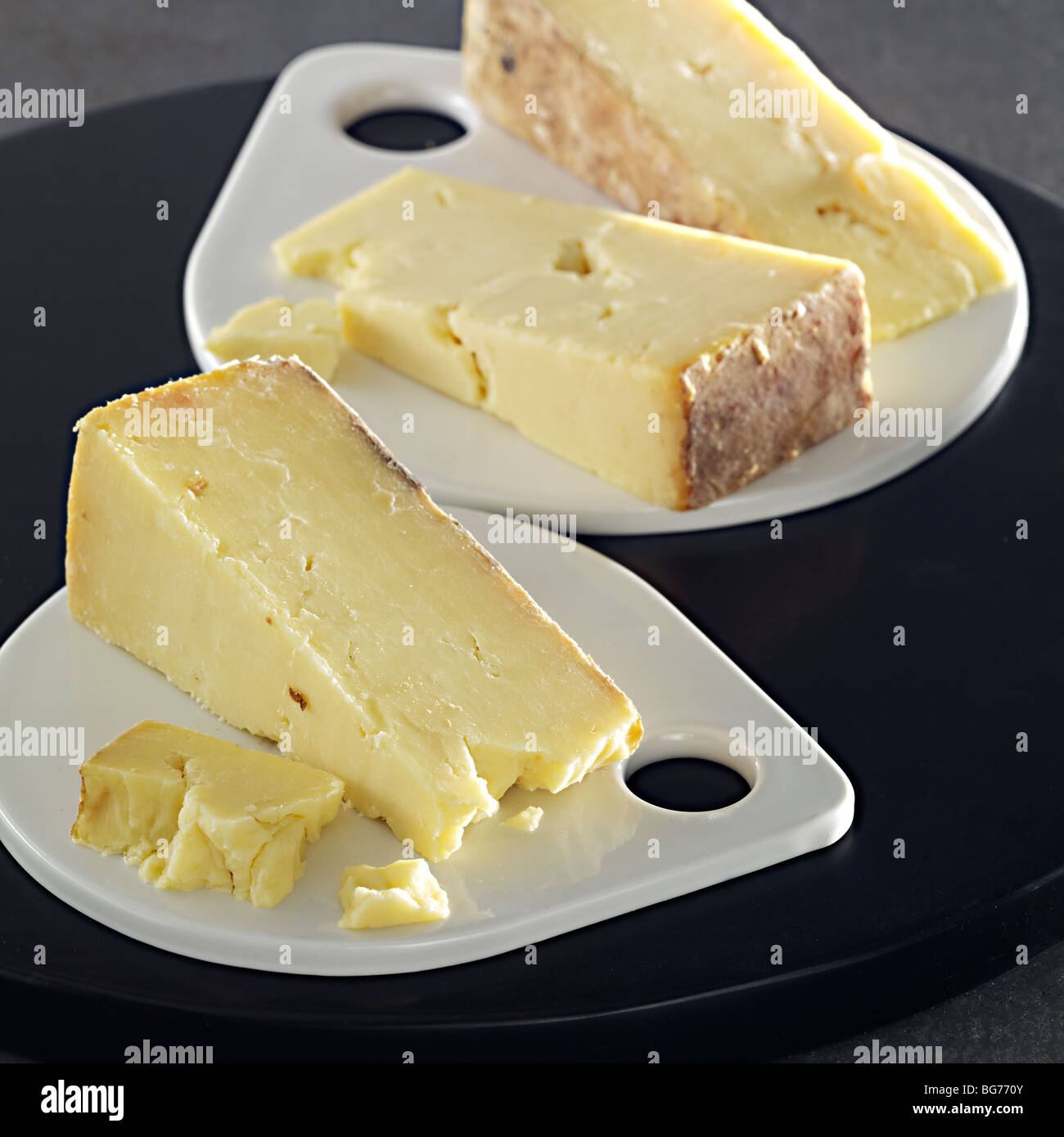 Cheddar cheese wedges on white flat plates Stock Photo - Alamy